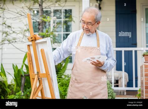 Lifestyle Asian Senior Old Man Painting Picture Artwork Using Brush And