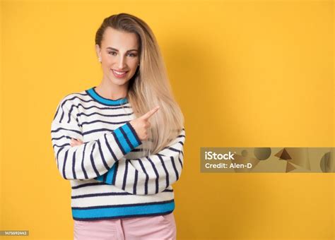 프레젠테이션 빈 공간을 가리키는 여자 복사 공간 노란색 배경에 격리된 제품을 제시하는 소녀 프로모터가 텍스트를 위한 공간을 표시합니다 20 24세에 대한 스톡 사진 및 기타