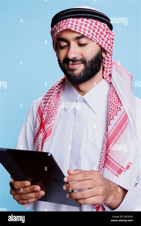 Muslim Man Wearing Traditional Clothes Holding Digital Tablet And