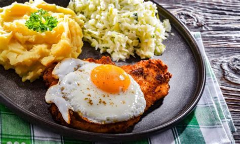Breaded Chicken Cutlet With Fried Egg Potatoes And Cabbage Stock Image