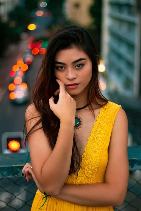 Mujer En Vestido Sin Mangas Con Cuello En V Amarillo Apoyado En La Valla · Fotos De Stock Gratuitas