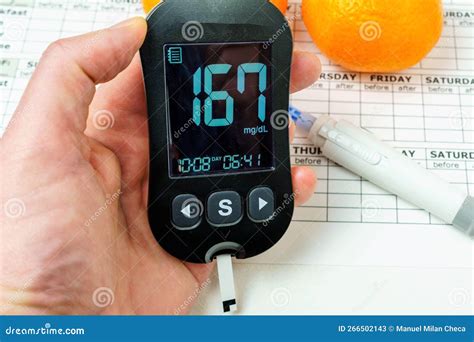 Hand Holding A Glucometer To Determine The Level Of Sugar In The Blood