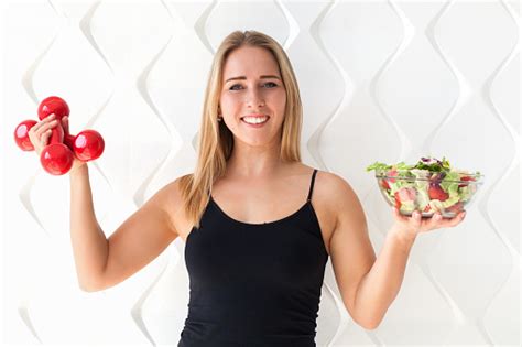 젊은 피트 니스 아령 레드와 그린 샐러드 유리 접시에 스포츠에서 모델 여자 선수 건강 한 생활 보디 빌딩 라이프 스타일 개념 이미지 복사 공간 텍스트 흰색 빈 배경입니다