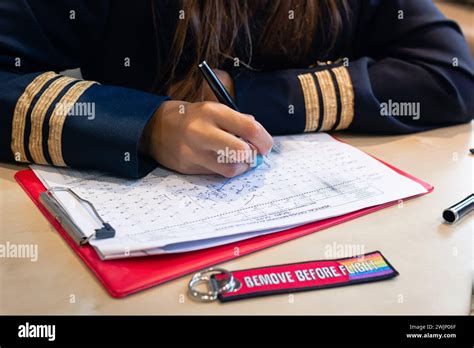 Unrecognizable Female Pilot Preparing Flight Documentation With A