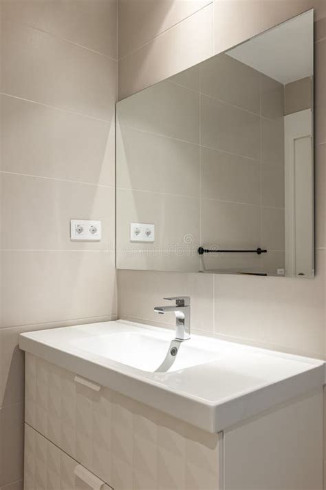 Simple Empty And Modern Bathroom With Beige Tiles Sink And Mirror