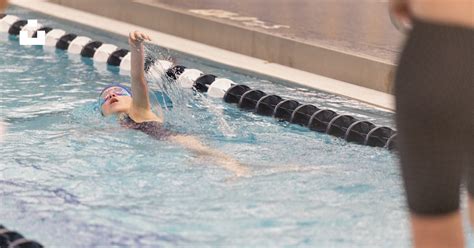 A Woman Swimming In A Pool With Her Arm In The Air Photo Free