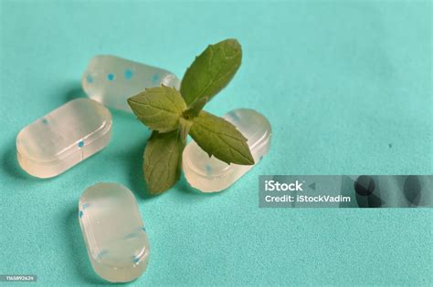 상쾌한 입냄새를 위한 페퍼민트 캔디 상쾌한 마이크로 그라누이 목의 통을 위한 냉각 멘톨 인근에는 신선한 민트 잎이 있습니다 민트 색상의 배경에 건강한 생활방식에 대한 스톡