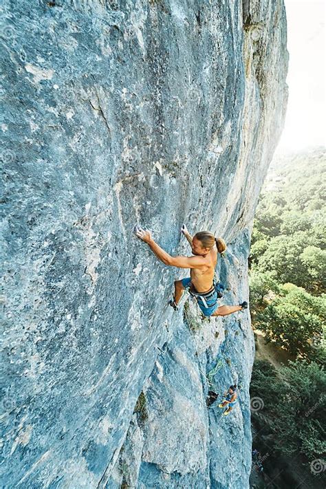 Strong Muscular Man Rock Climber With Naked Torso Dynamically Climbing