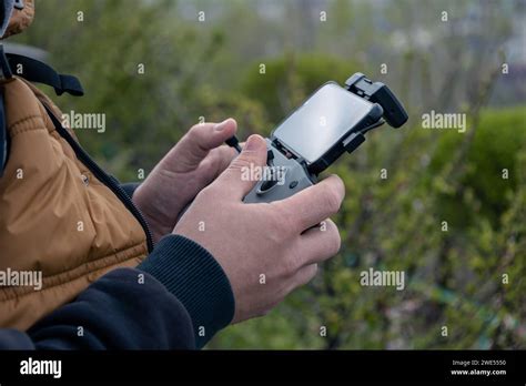 Male Hands Hold A Drone Control Panel With Connected Phone Close Up Management By Quadcopter