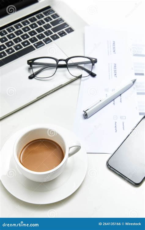Vertical Top View Of A White Office Table With A Notebook Glasses And