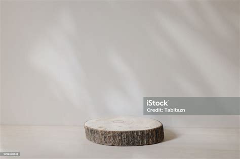 나무 원반 연단은 햇빛 아래 트렌디한 베이지색 배경에 놓여 있다 흰 벽 배경입니다 꽃 나뭇잎 그림자 플랫폼 고급스러움을 위한 받침대 천연 화장품 나무 쟁반 모형 제품 발표