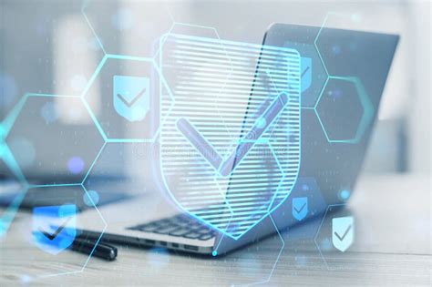 Close Up Of Laptop Computer At Desk With Glowing Hexagonal Shield Hologram And Binary Coding On