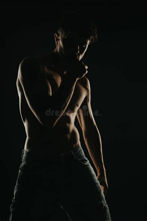Silhouette Of A Shirtless Man Thinking Deeply In Dark Moody Lighting