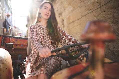 Premium Photo A Beautiful Girl In A Dress Rides An Old Tractor