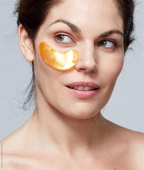 Woman Using Gel Eye Patch Mask By Stocksy Contributor Leandro Crespi
