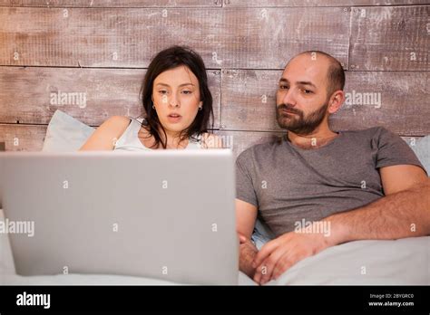 Beautiful Couple Spending Time In On Laptop Before Bedtime Couple In Pajamas Stock Photo Alamy