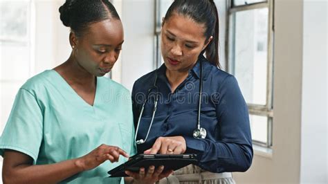 Healthcare Professionals Collaborating Using Digital Technology In A Clinical Setting Stock