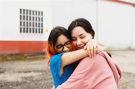 Dua Teman Yang Bahagia Salah Satunya Dengan Rambut Oranye Saling Berpelukan Penuh Kasih Saling