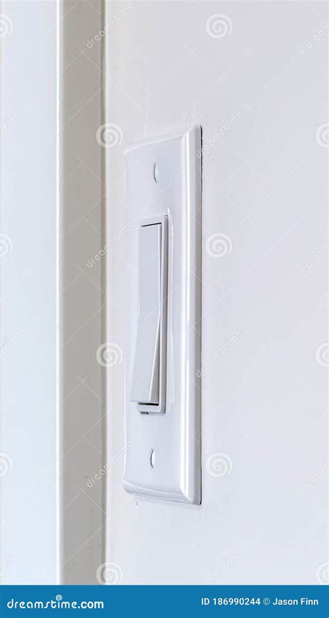 Vertical Side View Of Electrical Rocker Light Switch Mounted On White