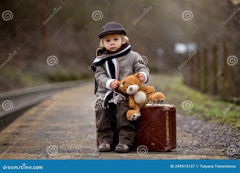 Adorable Boy On A Railway Station Waiting For The Train With Suitcase