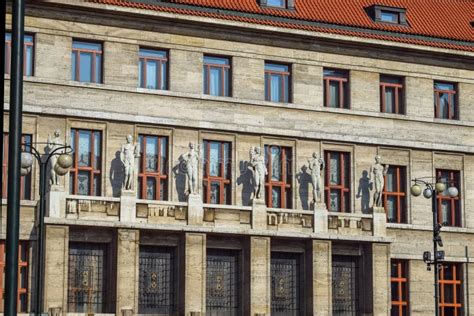 Sculptures Of Naked People Over The Entrance To The Building With A Shadow On The Wall Stock