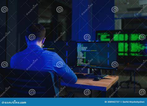 Male Programmer Working On Desktop Computer At White Desk In Office