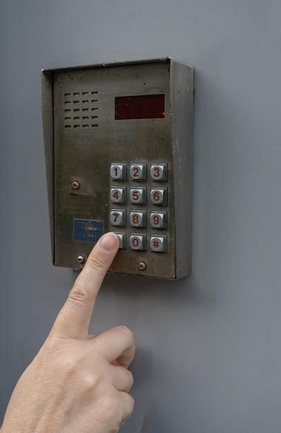 Premium Photo Secure Home System Hand Pressing On Intercom Keypad