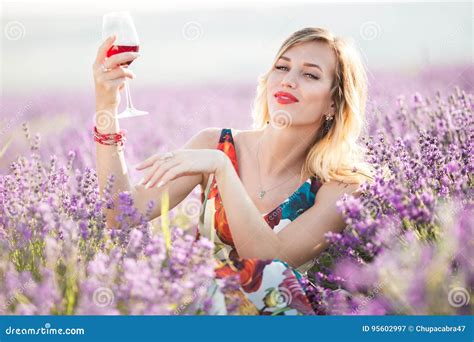 Portrait Of Beautiful Girl Is Drinking Wine In Lavender Field Stock