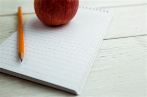 View Of An Apple And Notepad Premium Photo