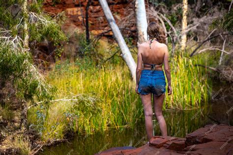 Premium Photo Beautiful Girl In A Bikini Stands On Red Rocks Above A