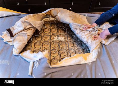A Man Cut A Spring Mattress With A Knife Spring Block And Foam Lining