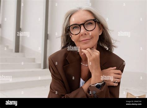 A Slender Senior Business Woman With Gray Hair And Glasses Is Dressed