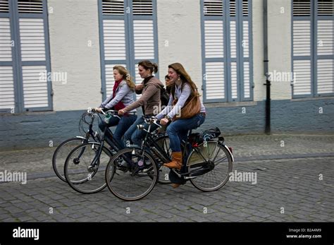 Three Girls Cycling On Push Bikes Bruges Brugge Flanders Belgium