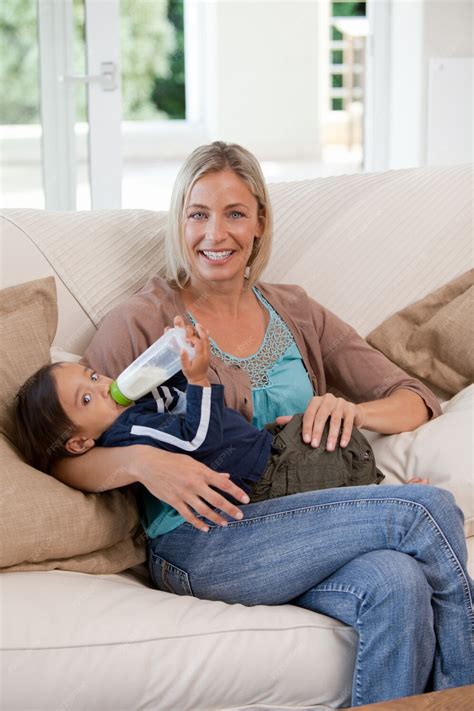 Premium Photo Mother Giving A Bottle Of Milk To Her Son