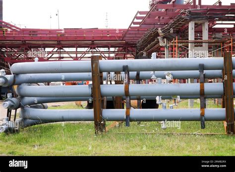 A Large Iron Metal Piping Trestle With Pipes And Electric Wires And Equipment At The